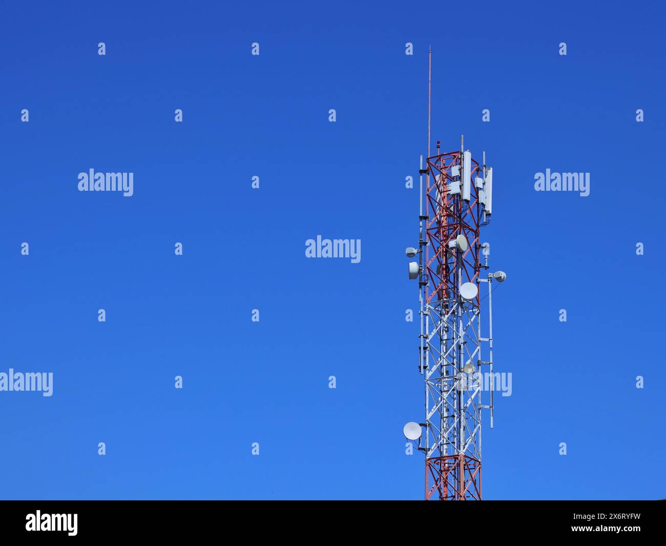 Cell towers tower high against a blue sky background Stock Photo - Alamy