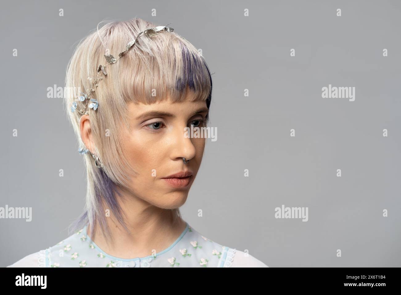 A side profile portrait of a young woman with blonde hair and purple ...