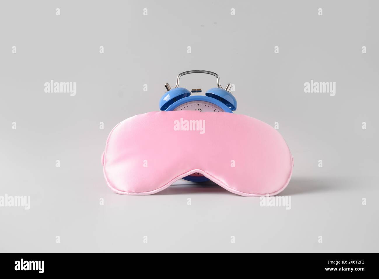 Pink sleeping mask and watch, alarm on gray background. Concept of ...
