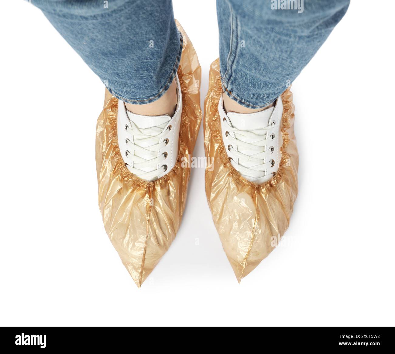 Woman wearing shoe covers onto her sneakers against white background ...