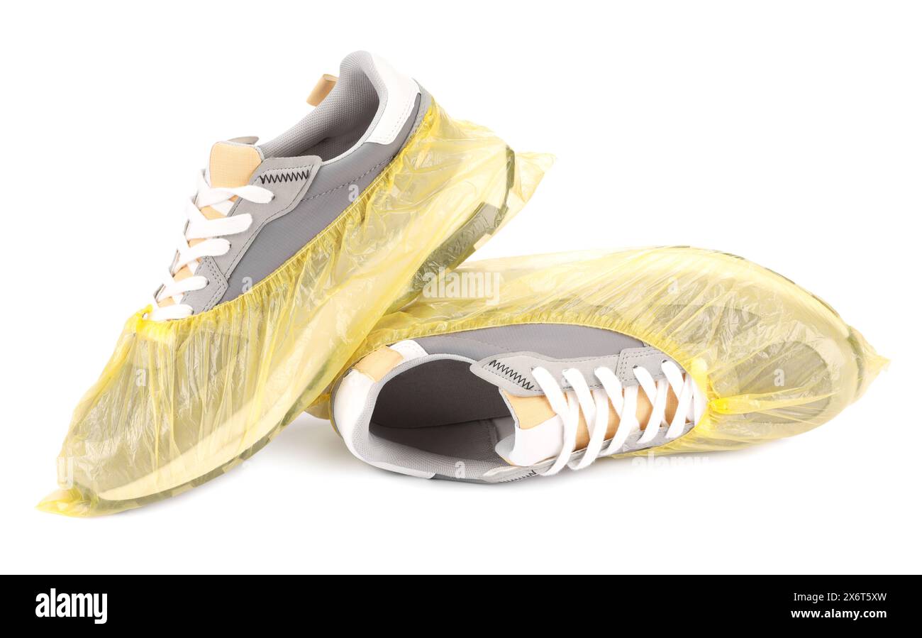 Men's sneakers in yellow shoe covers isolated on white Stock Photo - Alamy