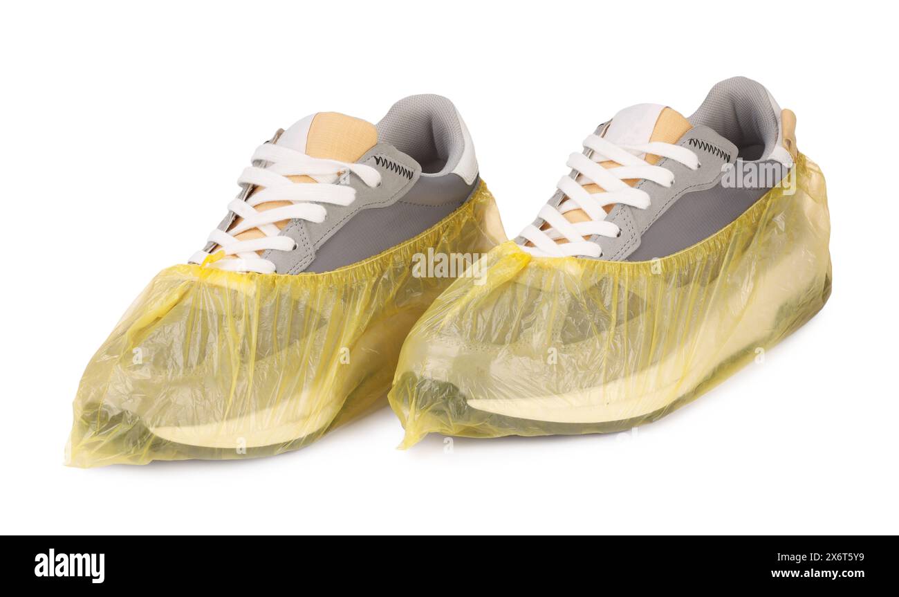 Men's sneakers in yellow shoe covers isolated on white Stock Photo - Alamy