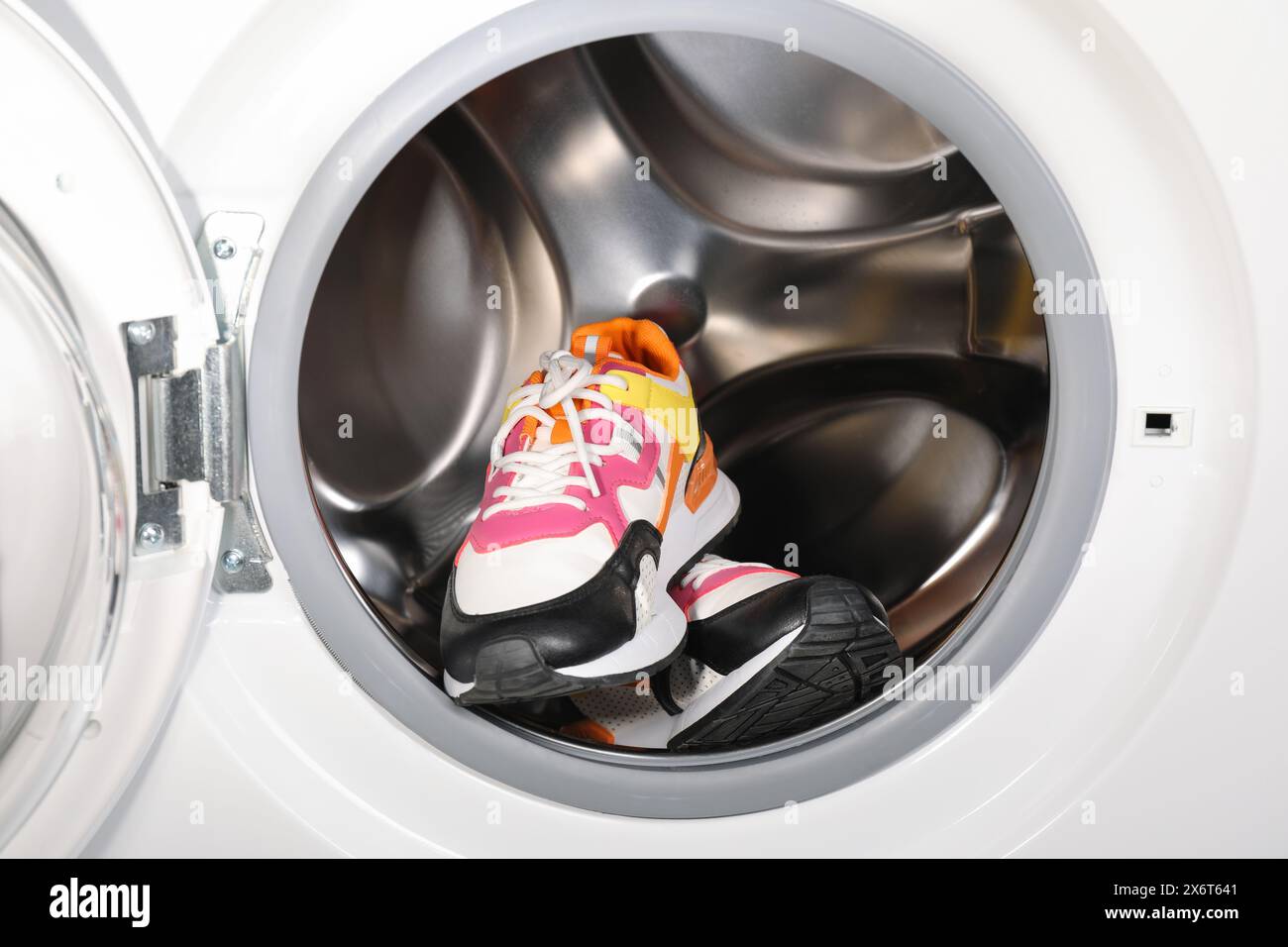Different clean sneakers inside modern washing machine Stock Photo - Alamy