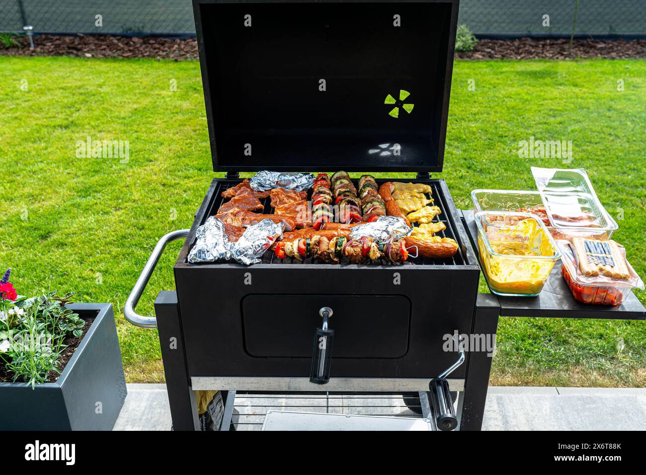 A modern rectangular grill standing on a paving slab on a garden ...
