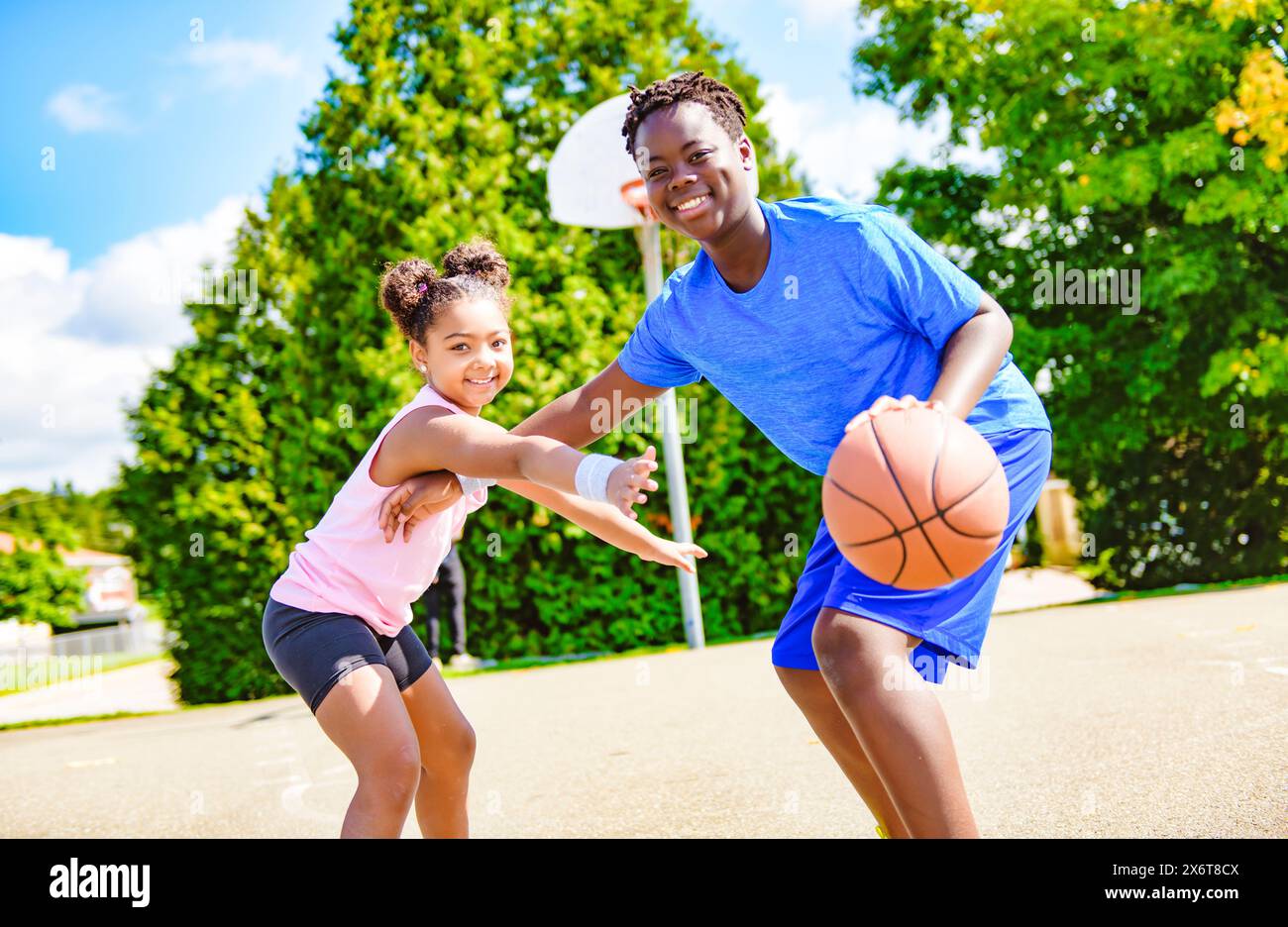 Portrait of brother and sister basketball player standing at basketball ...