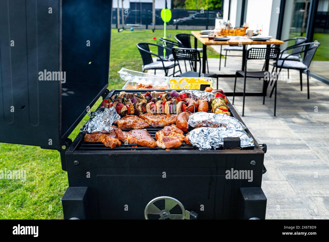 A modern rectangular grill standing on a paving slab on a garden ...
