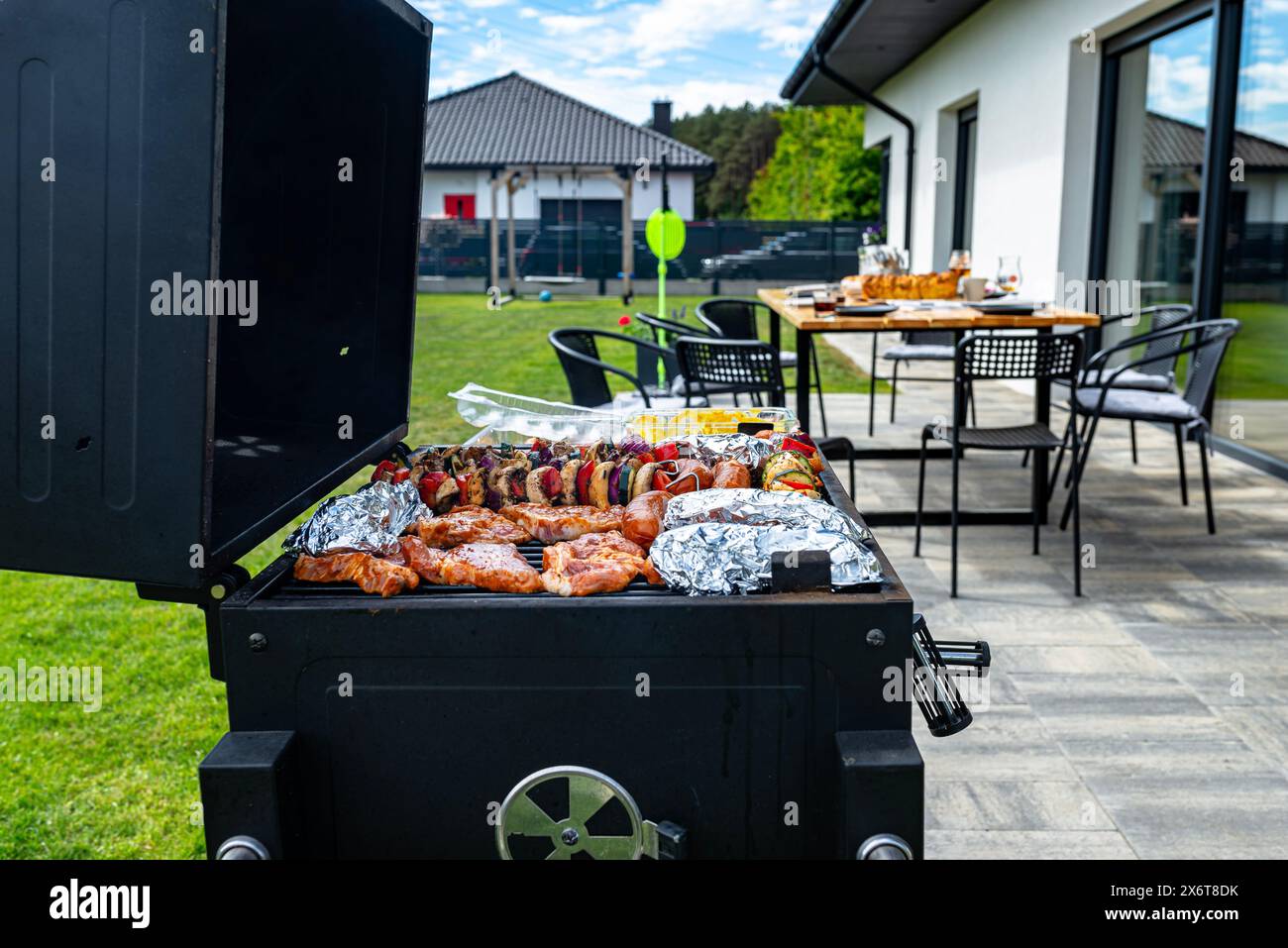 A modern rectangular grill standing on a paving slab on a garden ...
