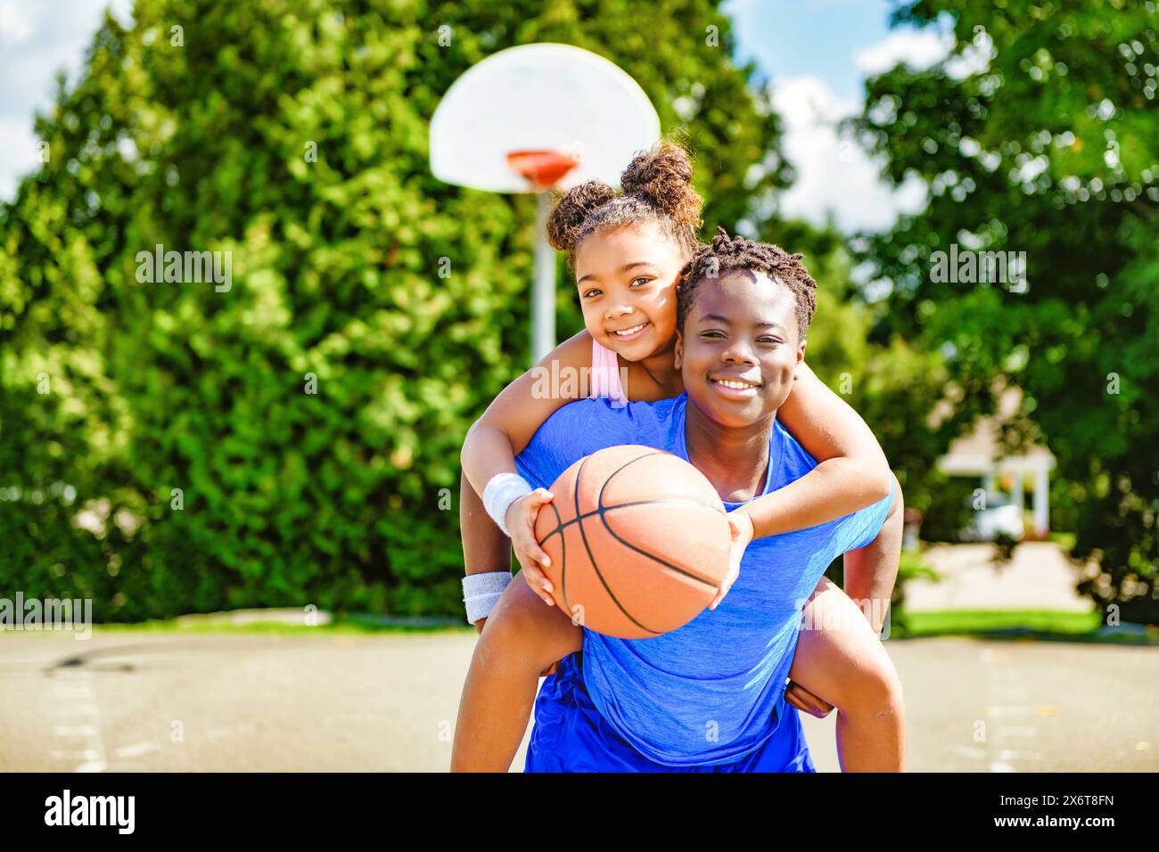 Portrait of brother and sister basketball player standing at basketball ...