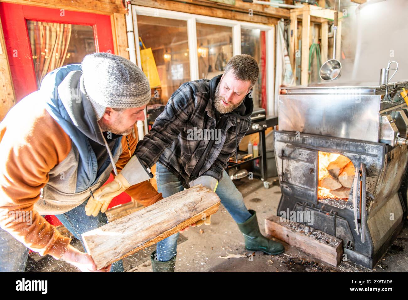 sugar shack, two maple farmers wearing a traditional clothe working ...