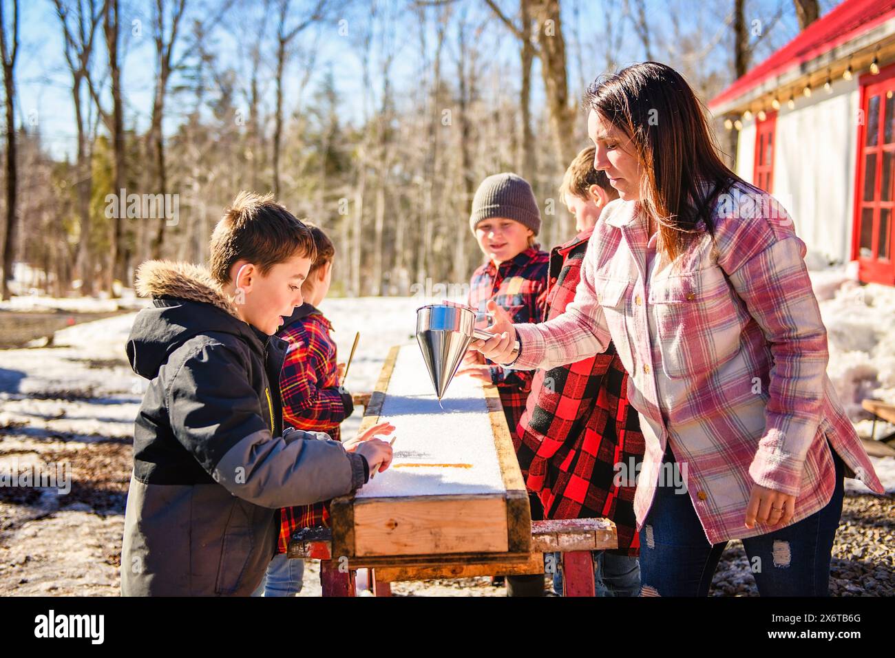 Photo showing children tasting maple syrup with wooden spoon Stock ...
