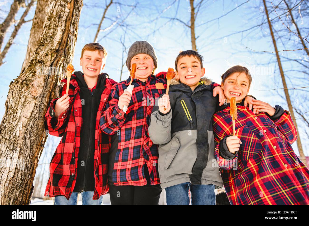 Photo showing children tasting maple syrup with wooden spoon Stock ...