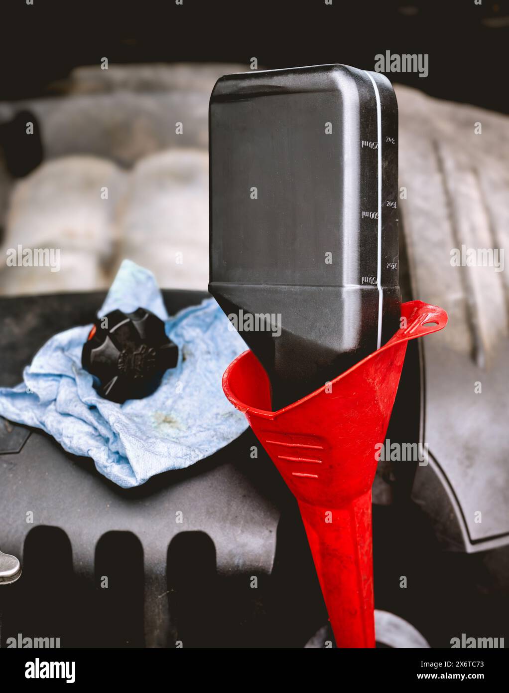 Filling a vehicle's engine with motor oil through a funnel Stock Photo ...