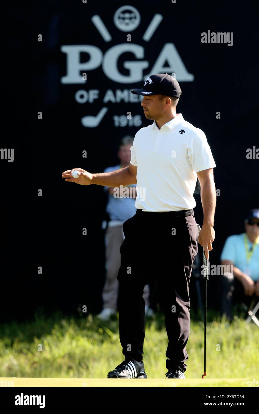 Xander Schauffele waves to the crowd after making his putt on the ...