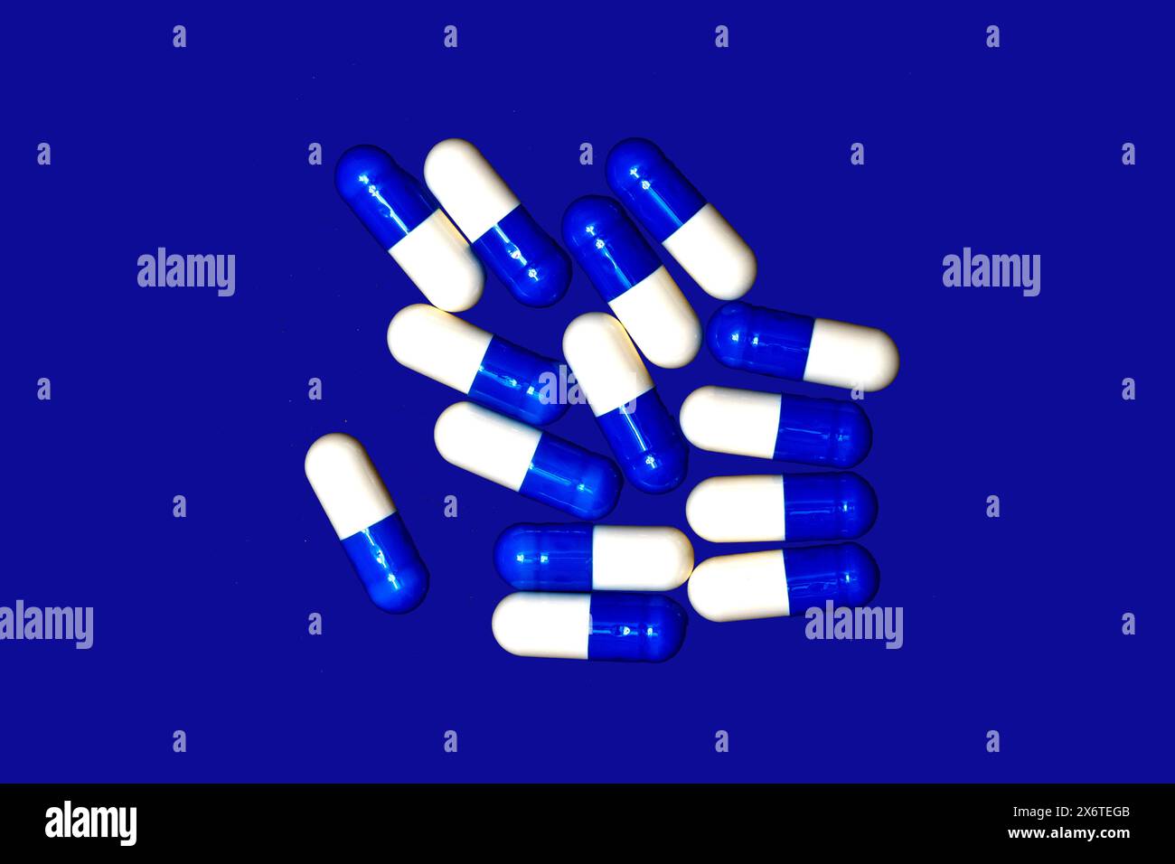 blue and white medicinal pill capsules on a blue background abstract ...