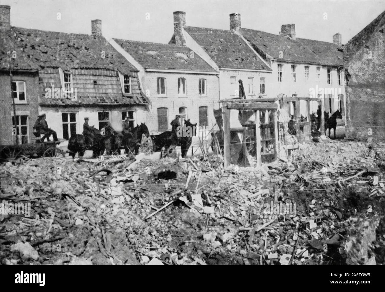 A photograph shows British soldiers advancing through the wreckage of a ...