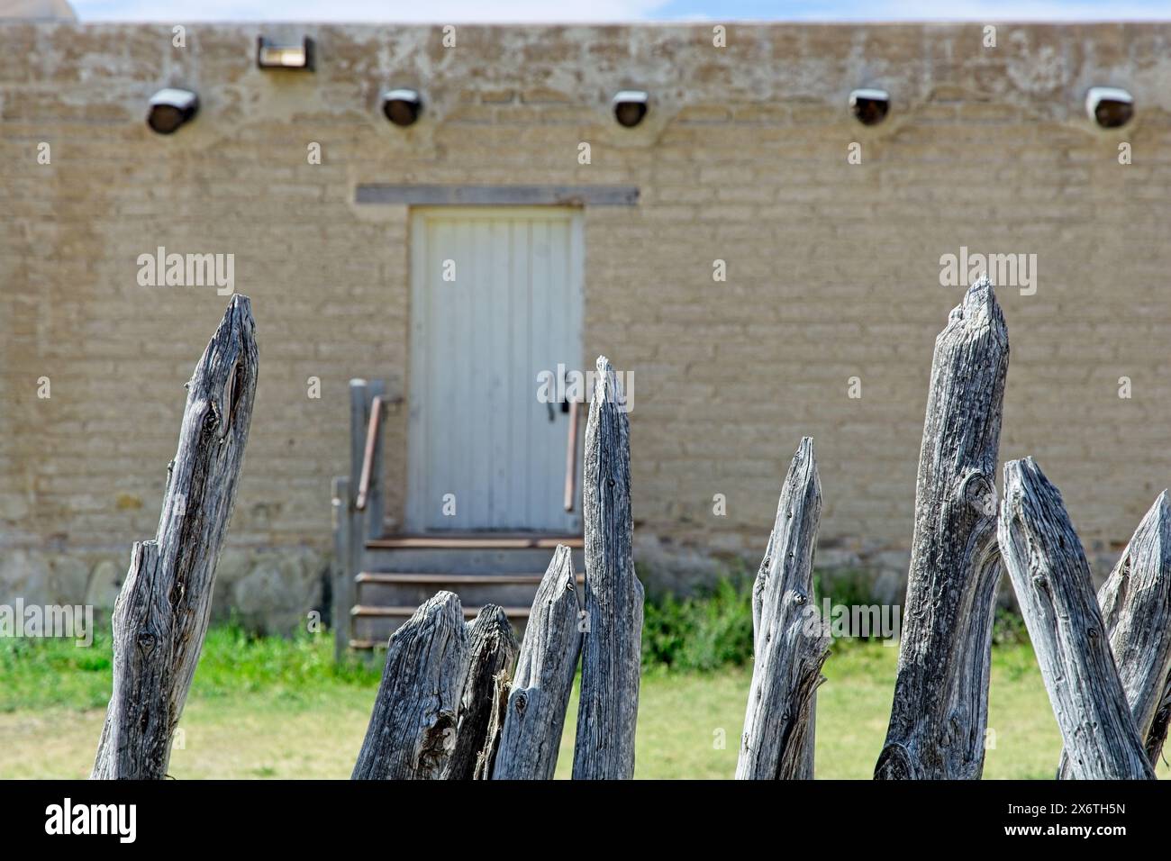 Rough picket fence before adobe barracks at Indian war era Fort ...