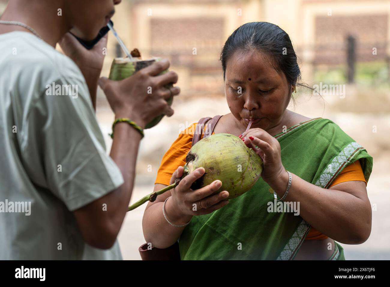 Assam, India on 16 May 2024. People drink coconut water along the ...