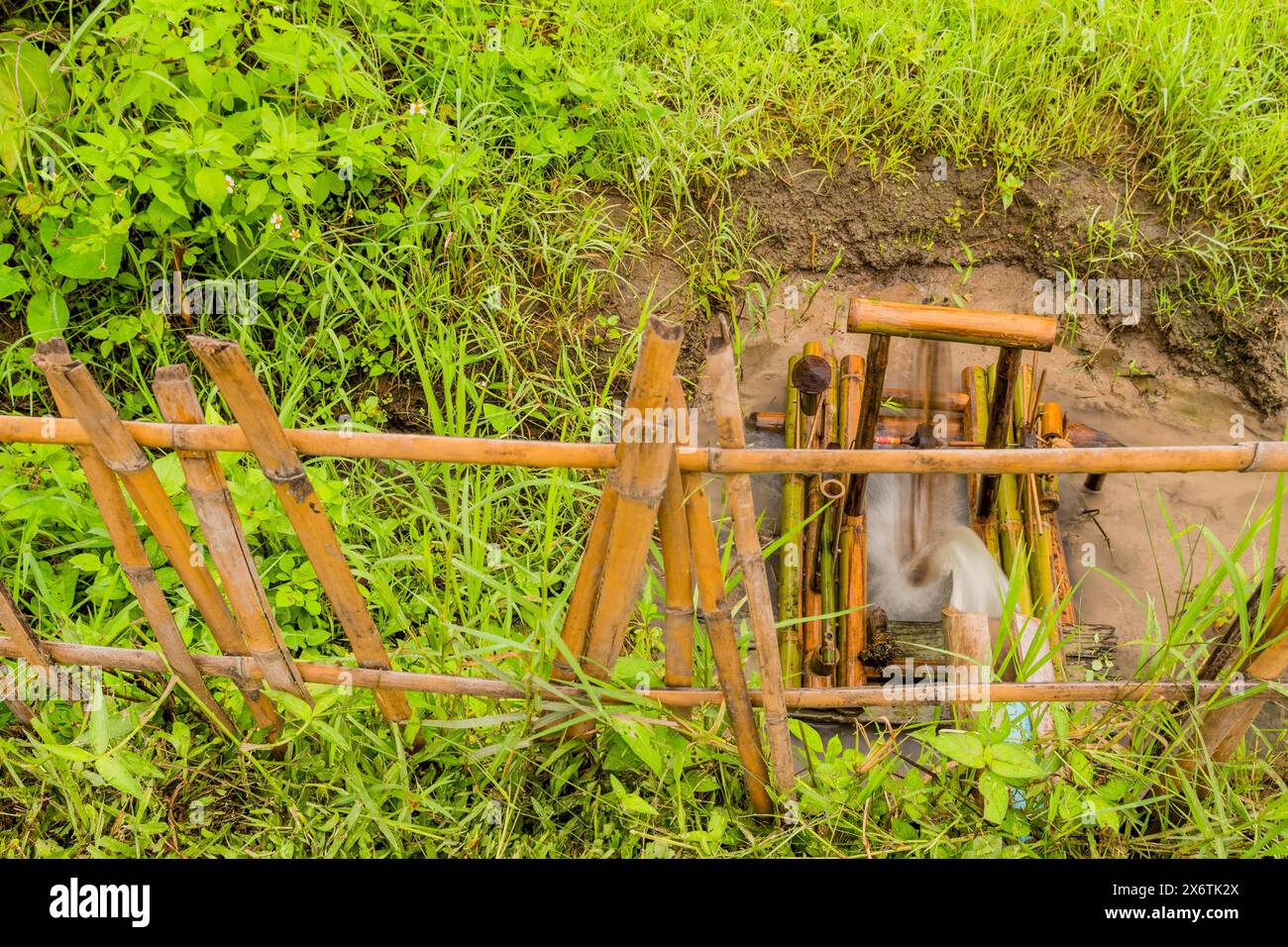 Water flowing from irrigation pipe spinning a small water wheel in ...