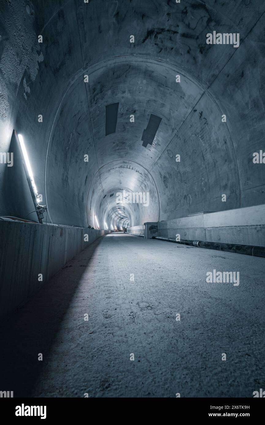 A long, barren tunnel with minimalist lighting and concrete walls that ...