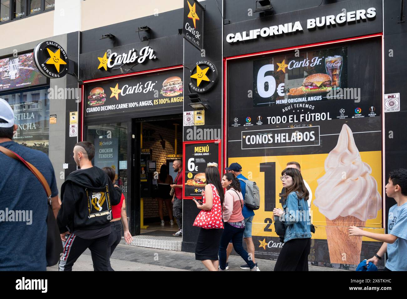 Pedestrians walk past the American fast food restaurant chain Carl's Jr ...