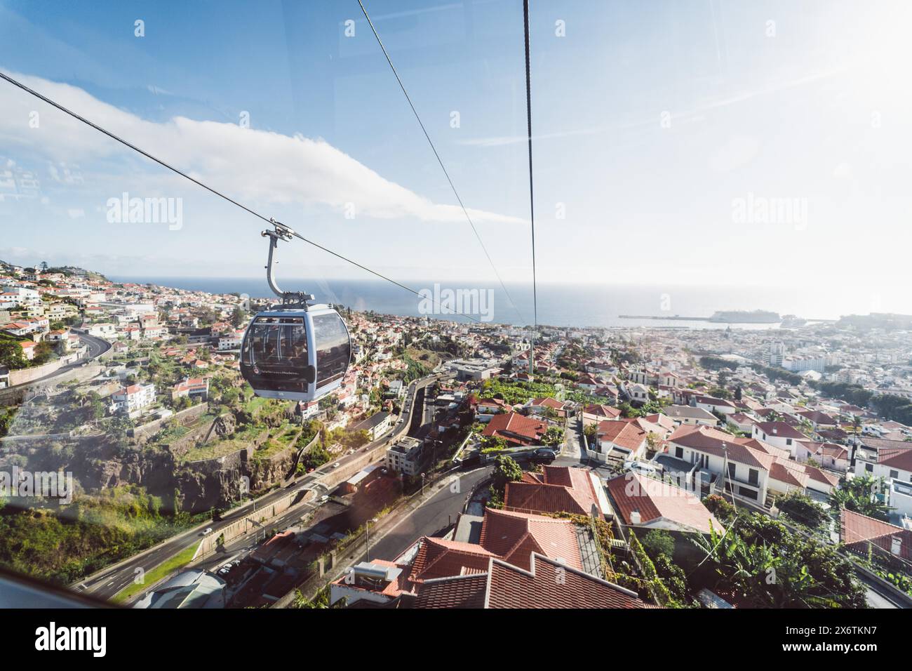Aerial cableway above a coastal town with a view of the sea and the ...