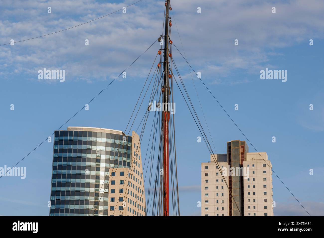 Sail mast between two modern buildings in front of a blue sky, skyline ...