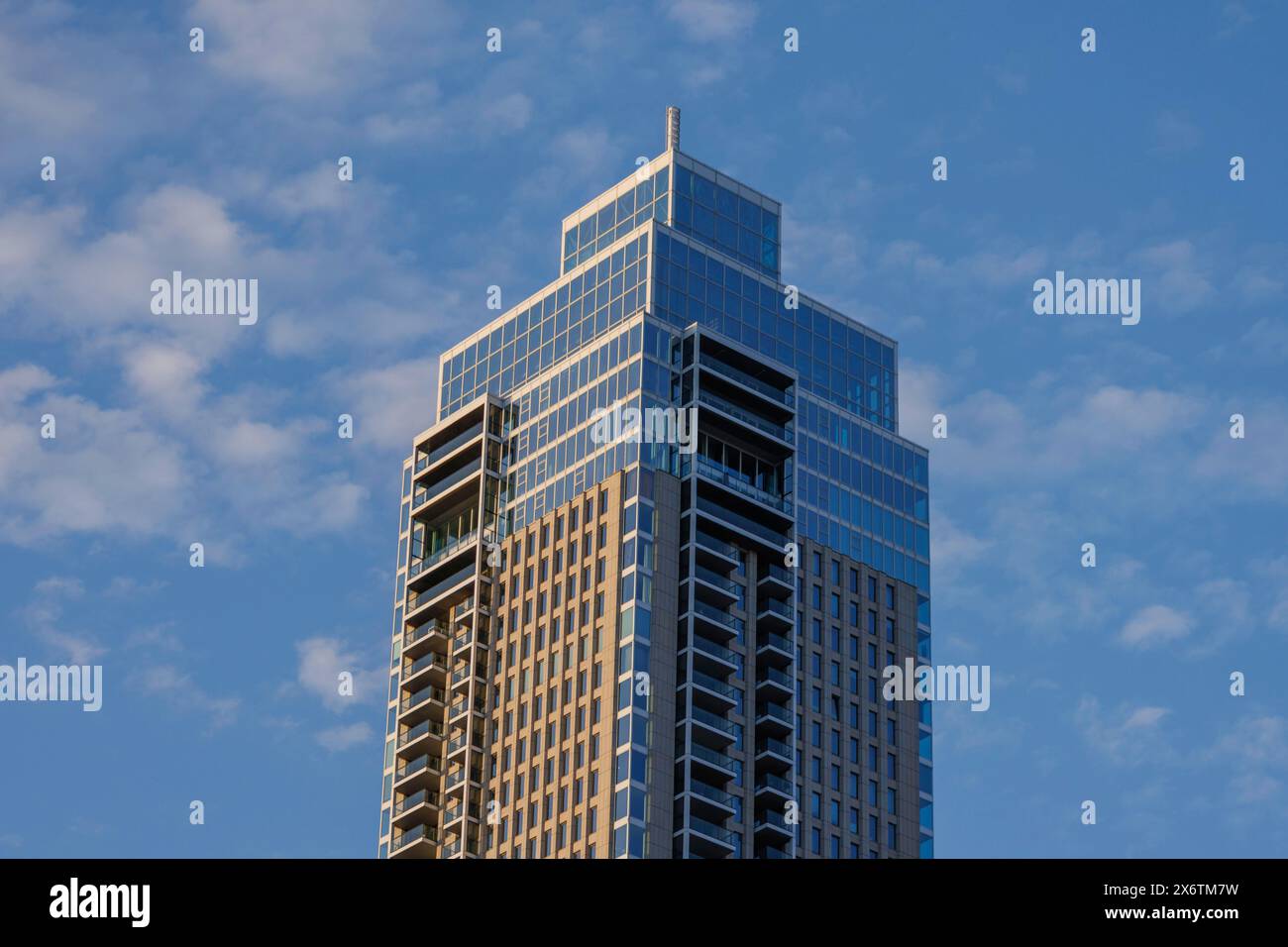 A modern skyscraper with glass facade in front of a clear blue sky with ...