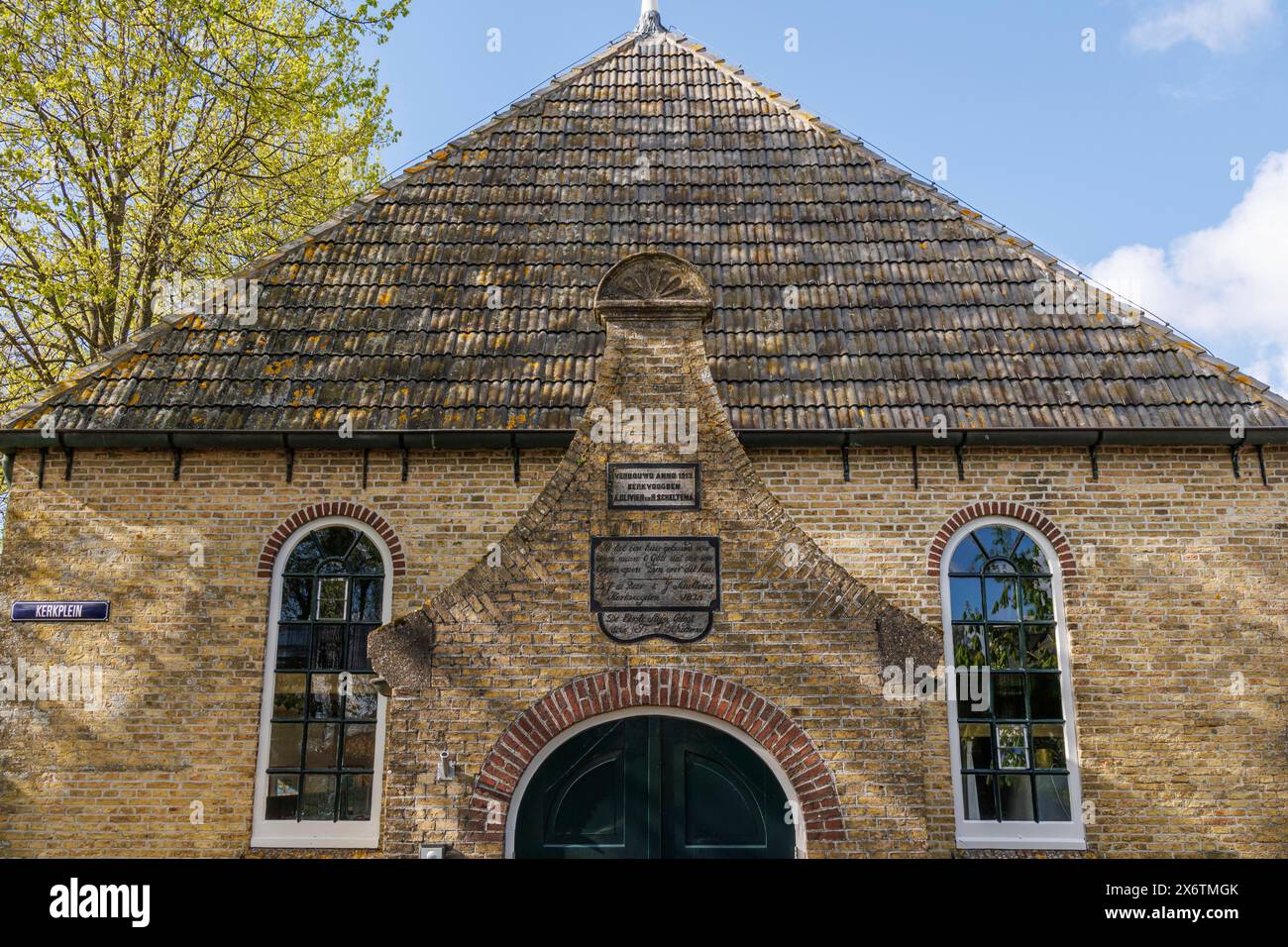 Traditional brick building with large roof, windows and a historic sign ...