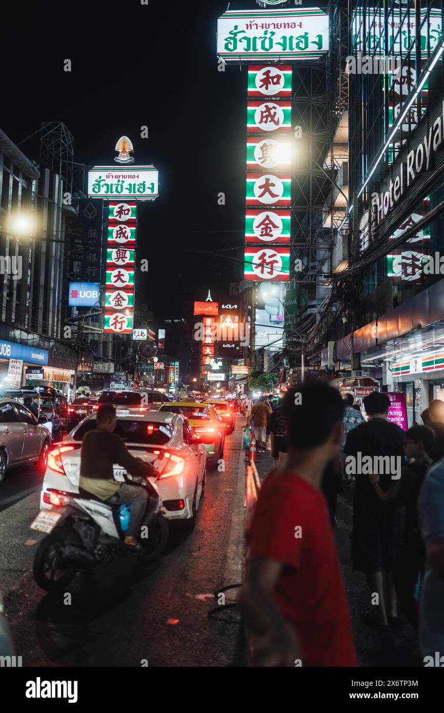 Street signs illuminated at night with Chinese characters light up the crowded streets of ...