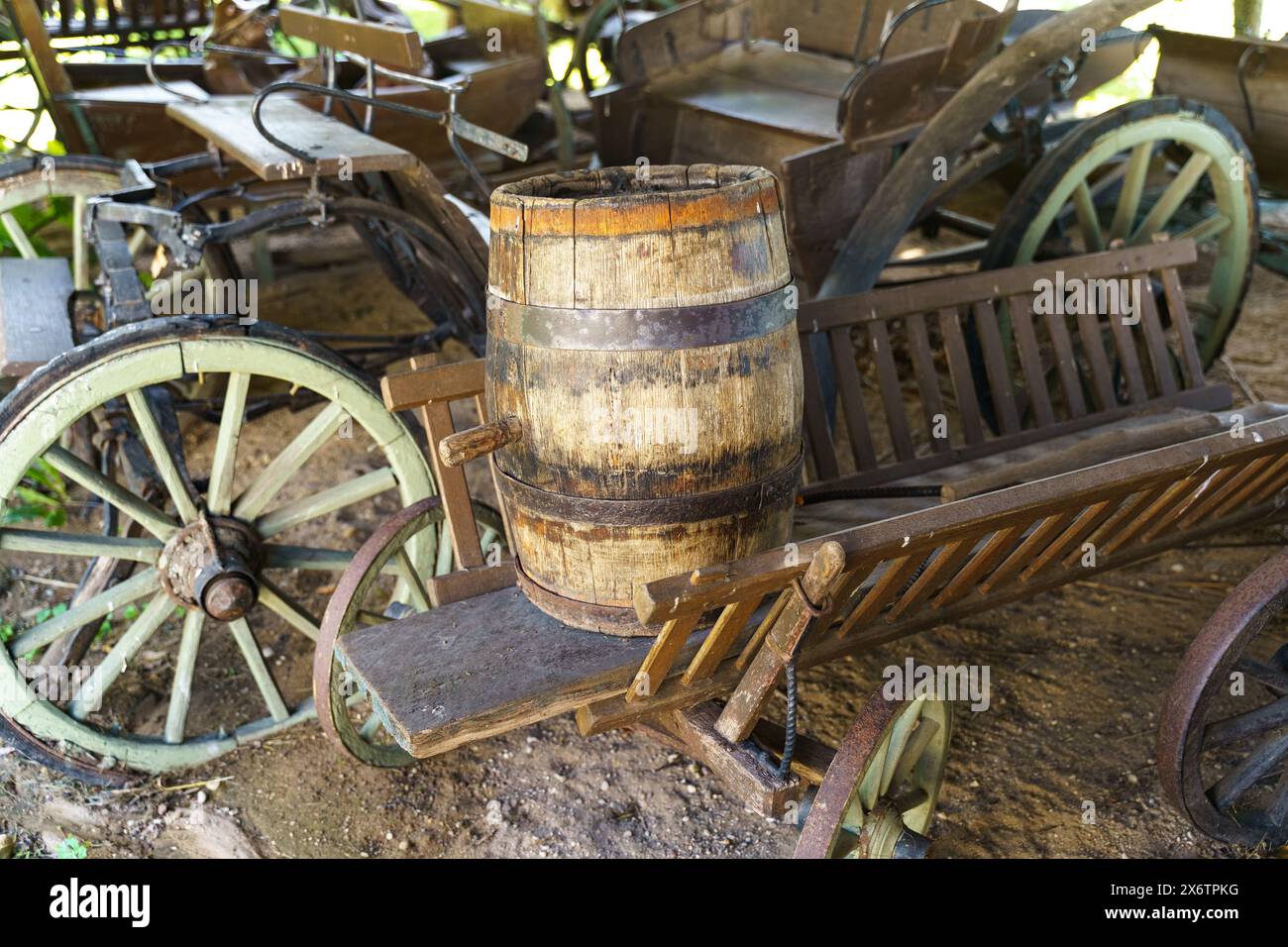 An old-fashioned wooden cart carrying a wooden barrel on top of it ...