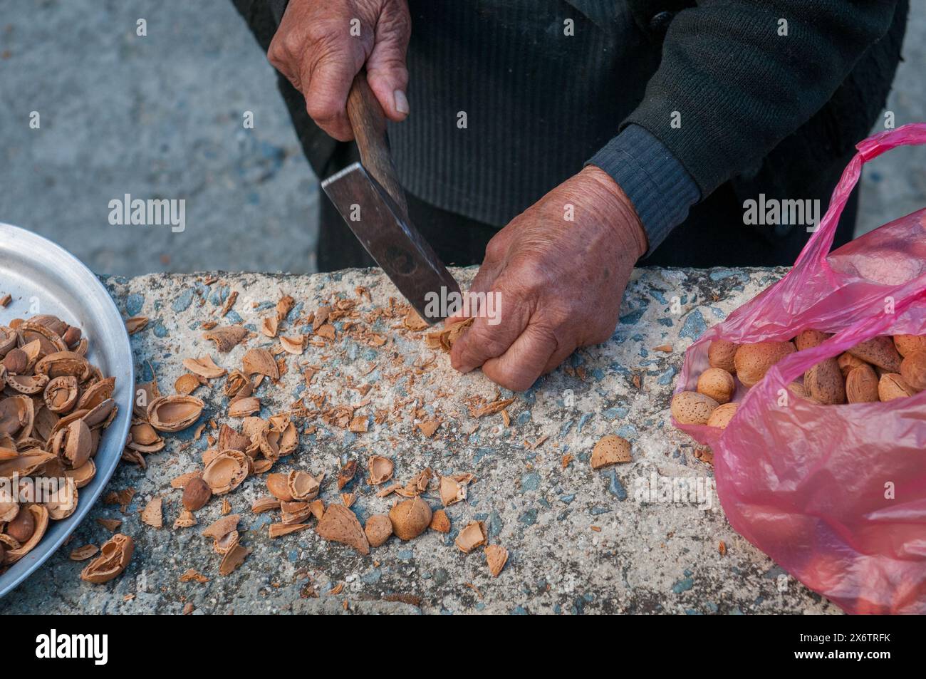 Elderly person cracking almonds by hand Stock Photo - Alamy