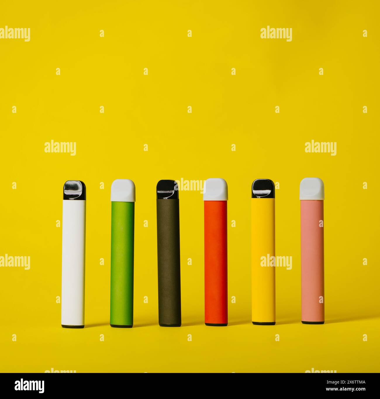 Set of colorful disposable electronic cigarettes with shadows on a ...