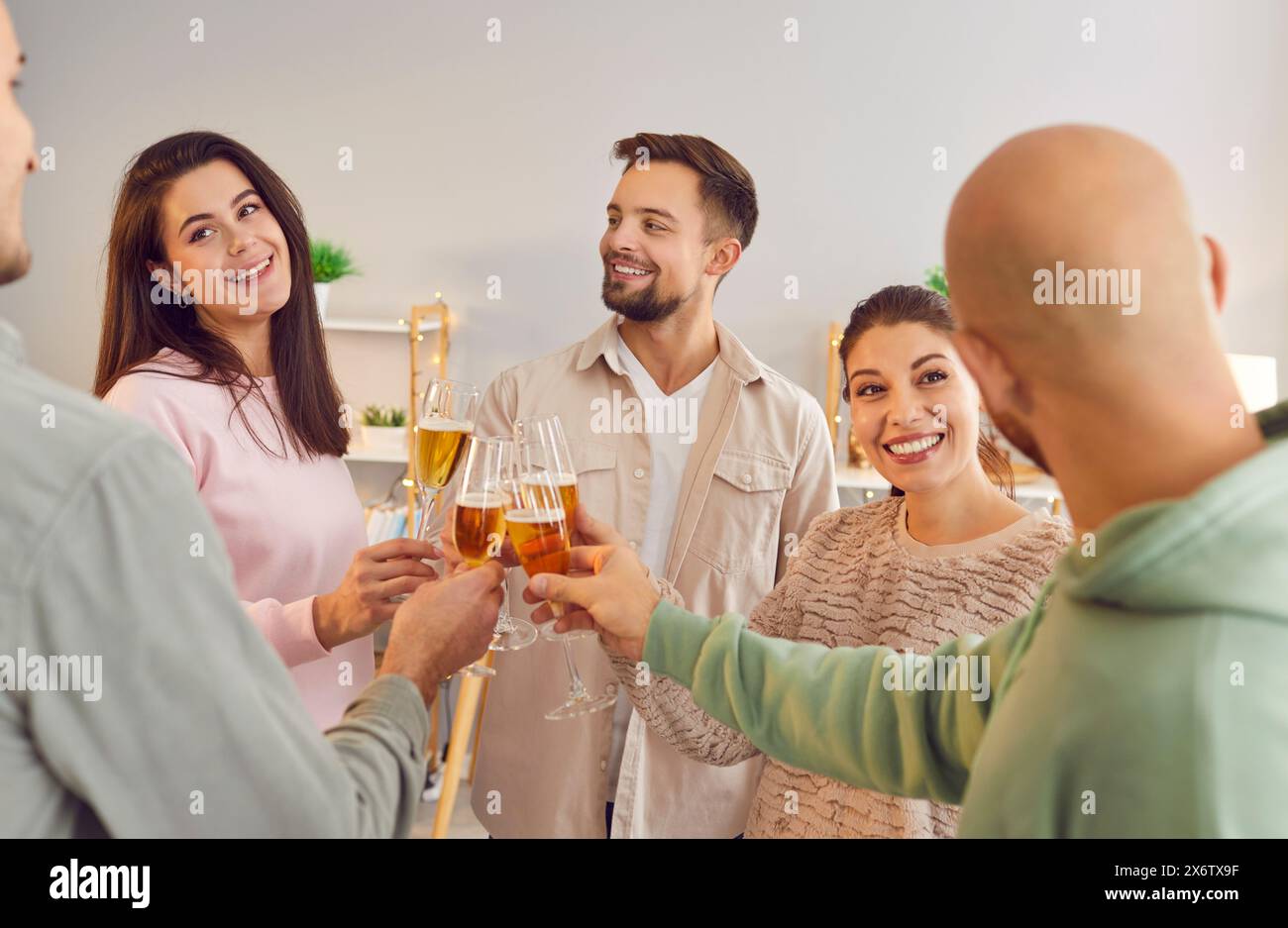 Group of young friends toasting wine glasses and talking standing in a ...