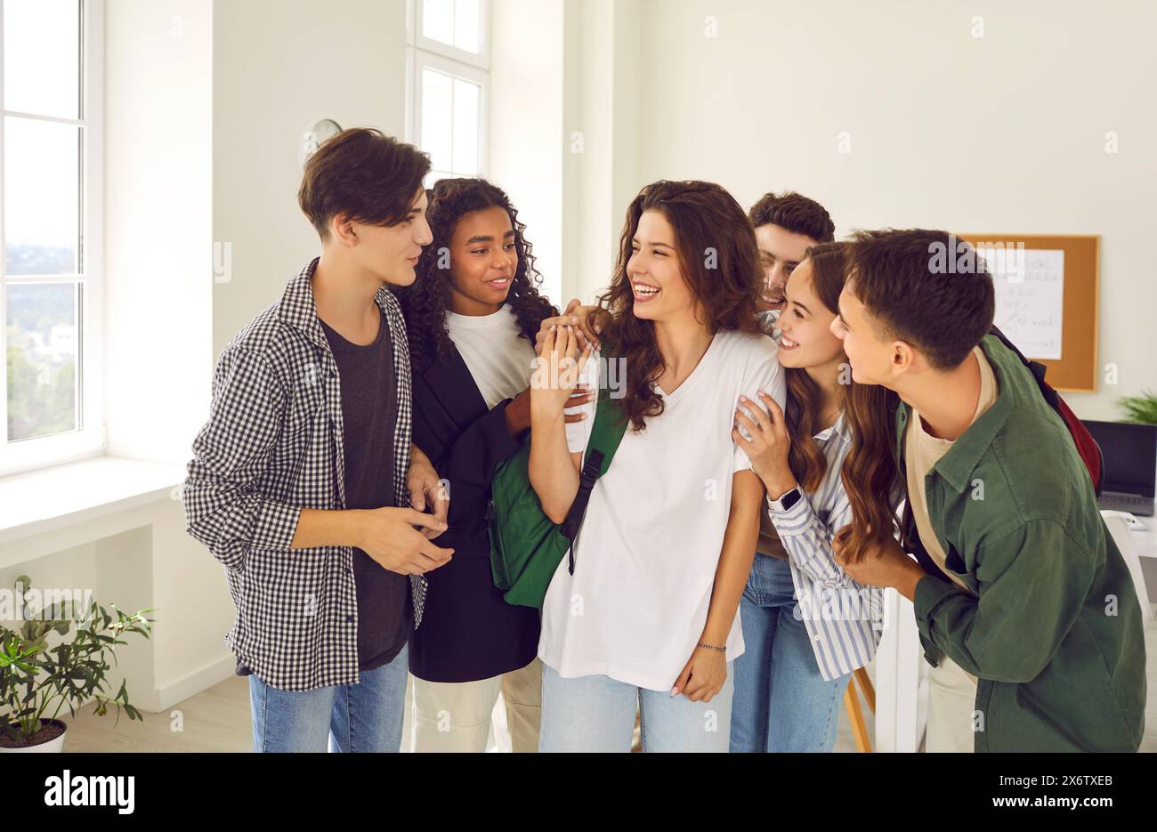 Happy laughing school students standing together in classroom and ...
