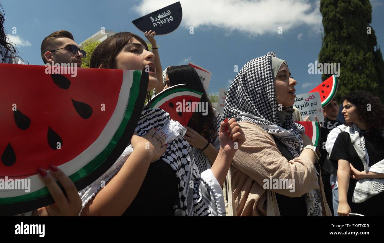 Israeli Arab students hold signs in the colors of the Palestinian flag ...