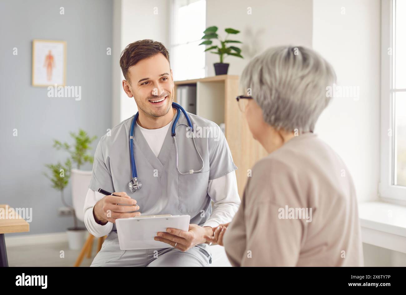 Friendly doctor gives informative medical consultation to elderly woman during clinic ...