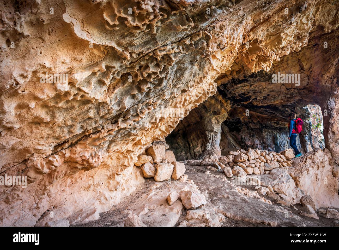 tourist in Sa Cova des Voltor, (the vulture cave), historic sandstone ...