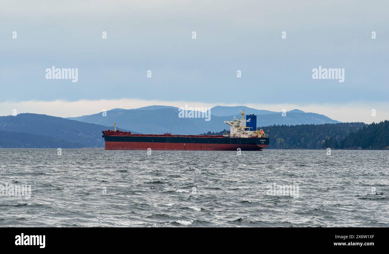 An oil tanker ship passes through the island and mountain landscapes of ...