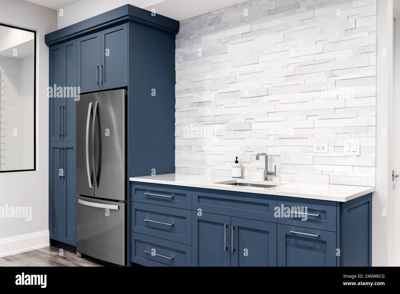 A luxury kitchen detail with blue cabinets, a white marble countertop ...
