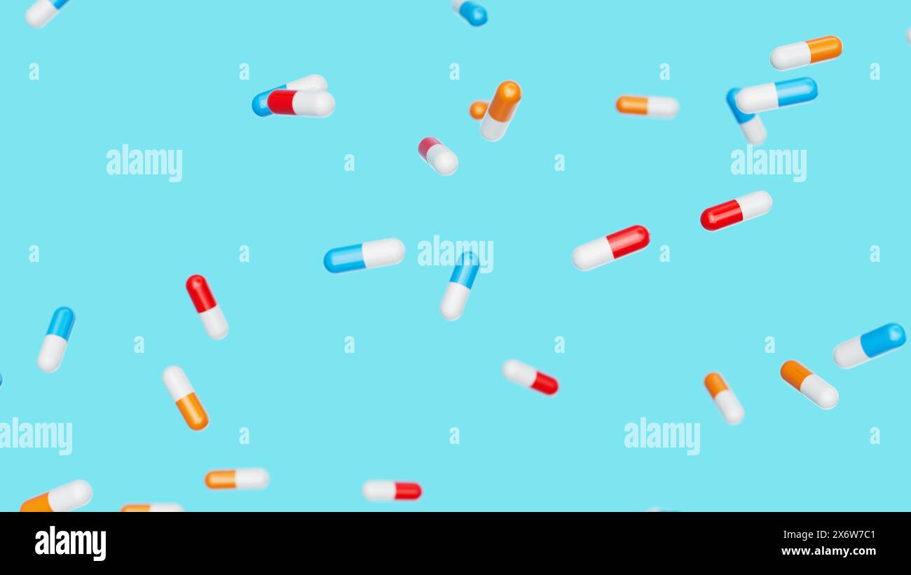 Colorful capsules fall against blue backdrop. Drugs, pills, tablets ...