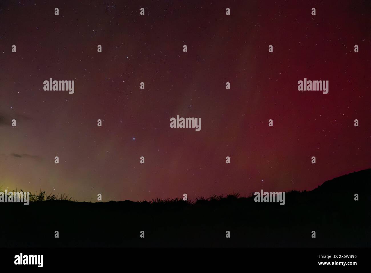 Yellow beams against the red glow of Aurora Australis with pink beams ...