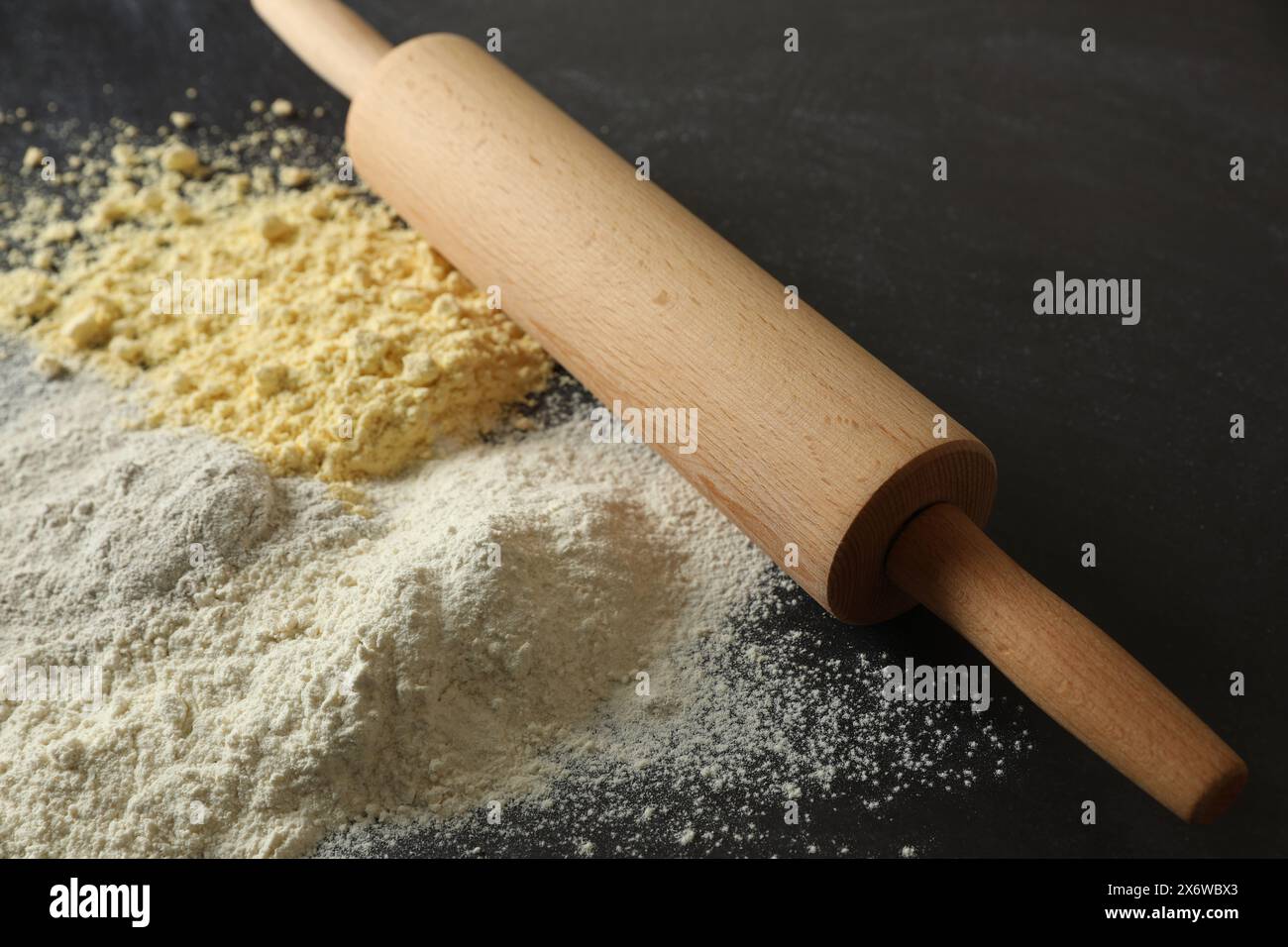 Rolling pin and different types of flour on black table, closeup Stock ...