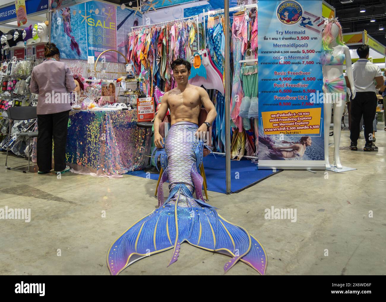 The booth of Mermaid Princess Thailand showcases a male dressed in a ...