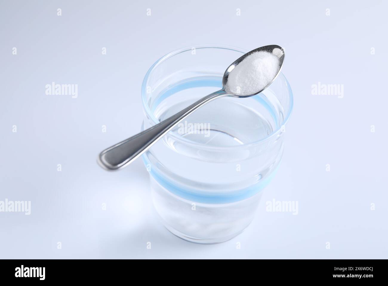 Glass of water and spoon with baking soda on white background Stock ...