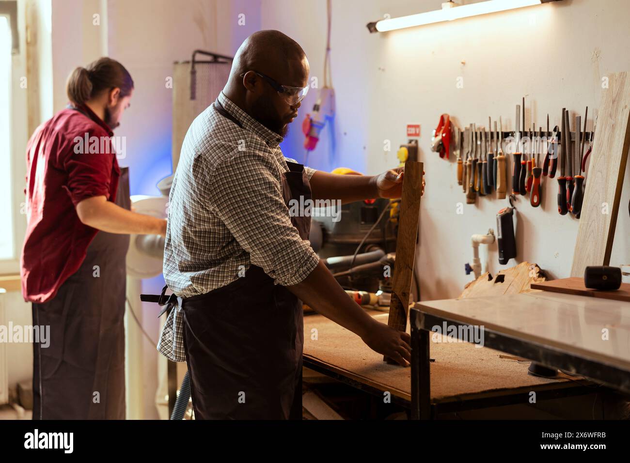 African american manufacturer wearing safety goggles while working with ...
