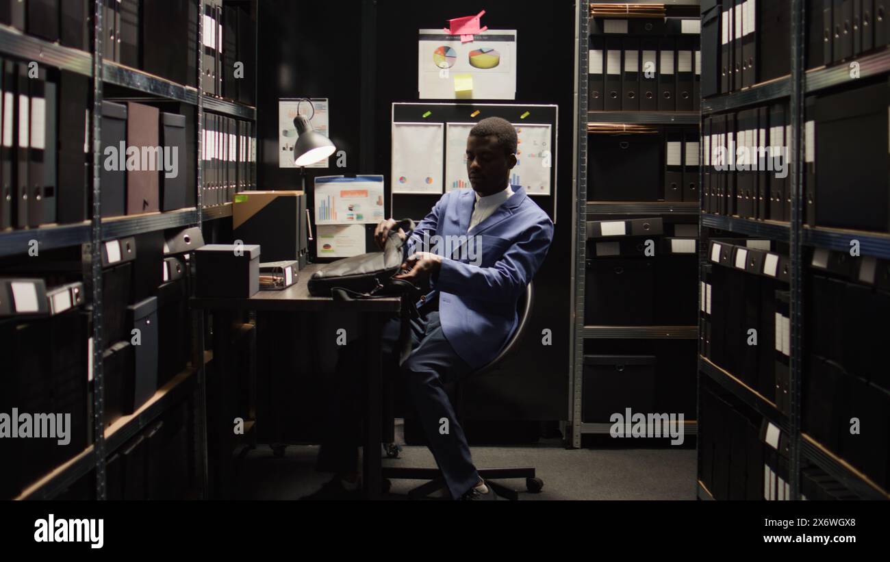 Male detective inspector carefully examines evidence files while ...