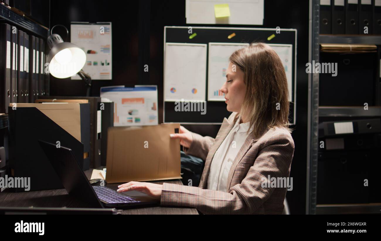 Close-up of caucasian female detective closing laptop and folder ...