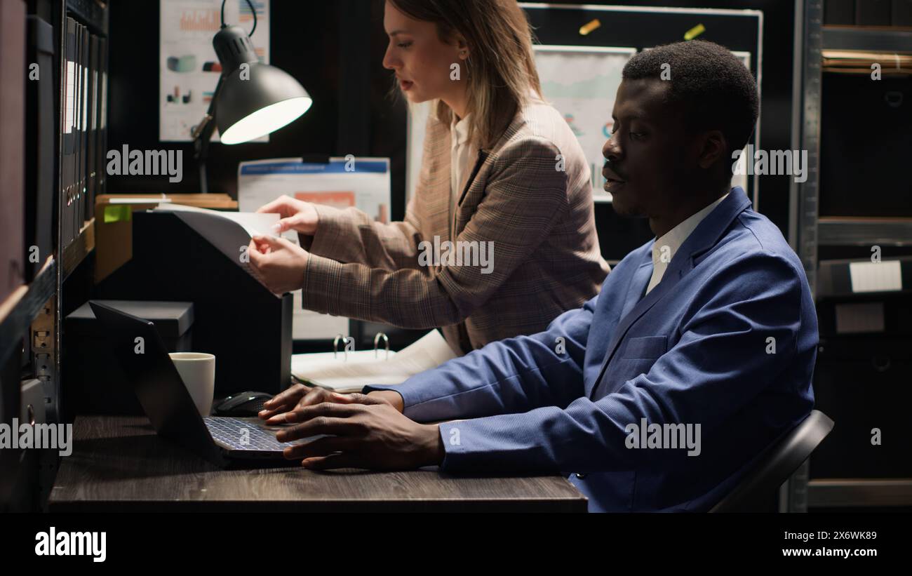 Multiethnic investigators analyzing clues, reviewing records, and ...