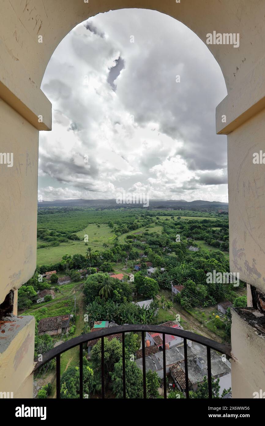 299 Land of the Manaca Iznaga Estate under cloudy sky framed by an arch ...