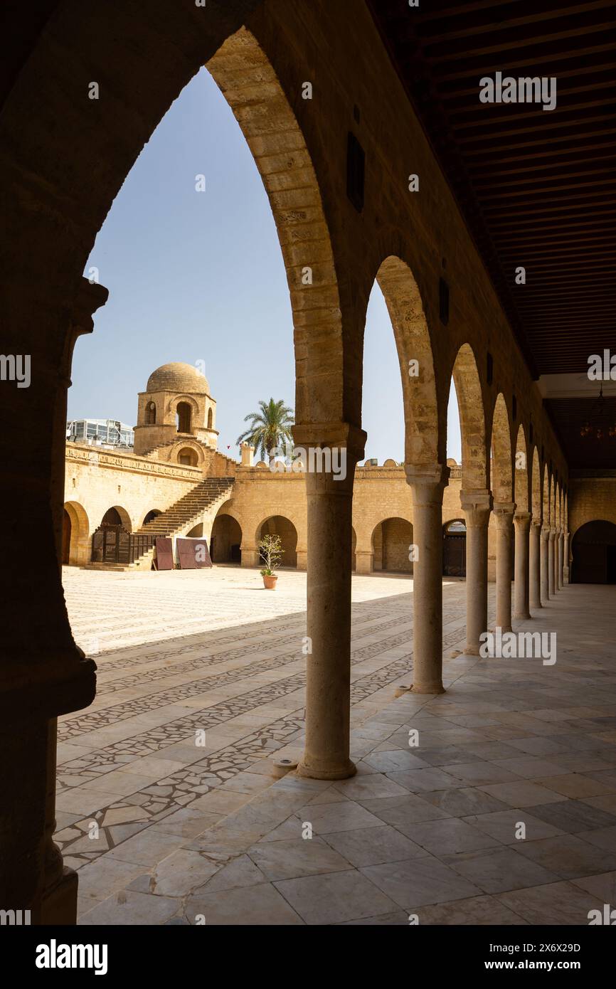 View from shaded archway onto courtyard of Great Mosque of Sousse with ...